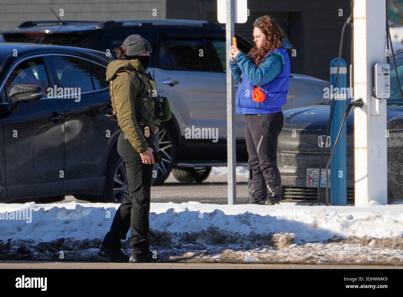 A woman films a Homeland Security Investigations agent at a parking lot ...