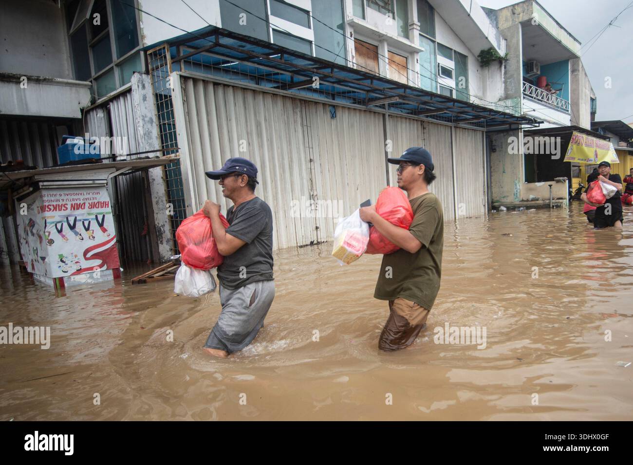 (260123) -- JAKARTA, Jan. 23, 2026 (Xinhua) -- People wade through ...