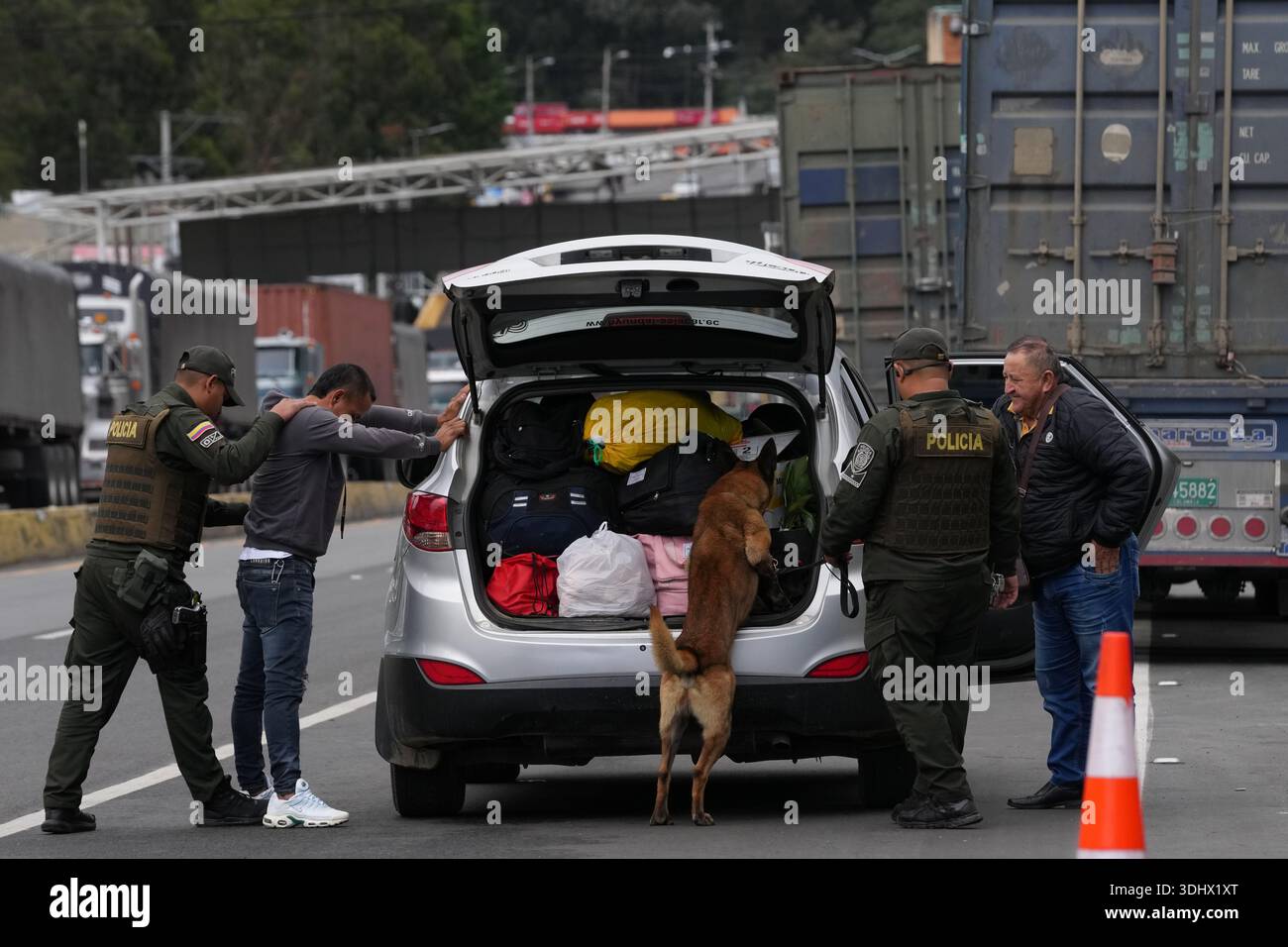 Colombian police and their search dog inspect a car and its occupants ...