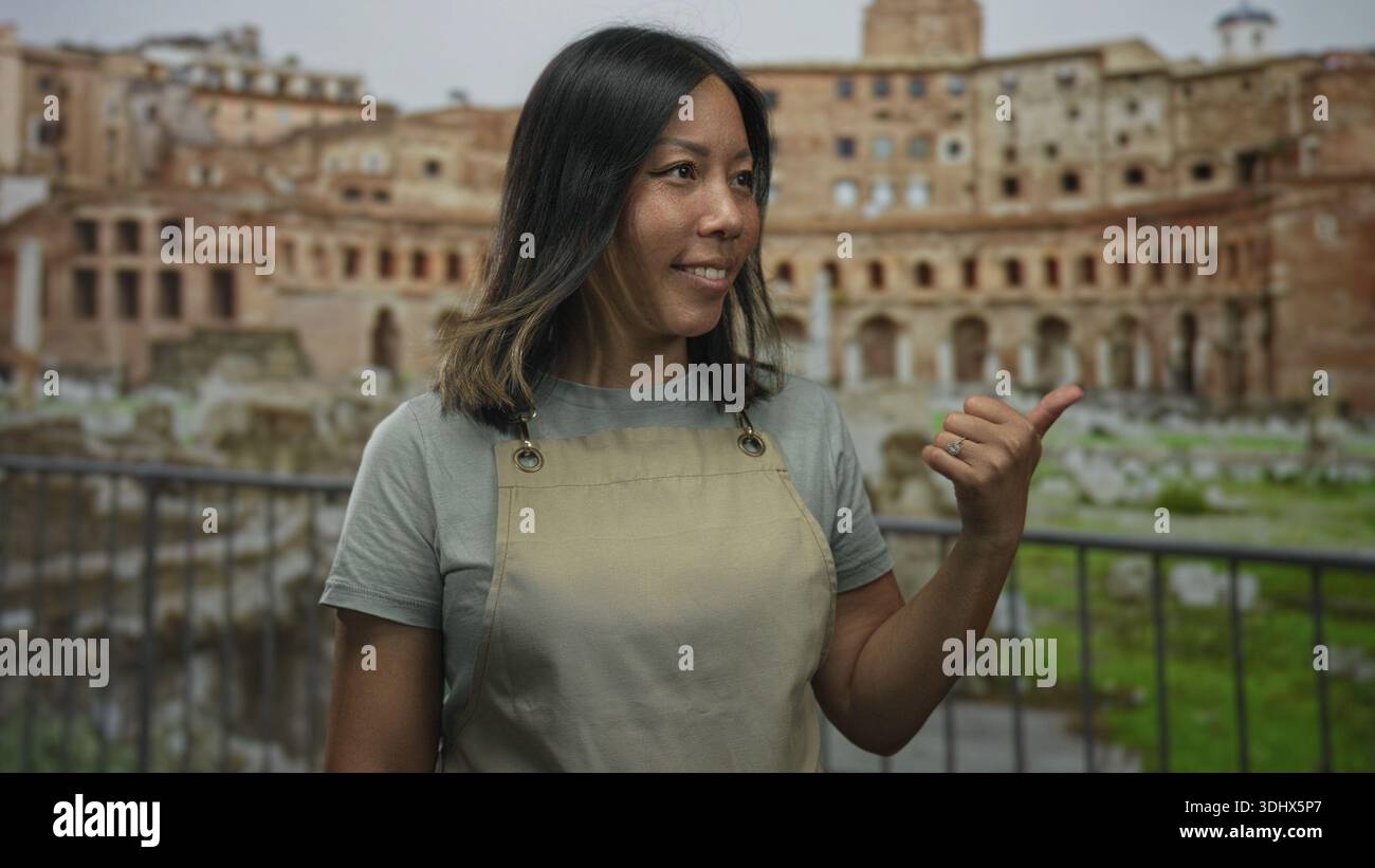 Woman points thumb over shoulder toward roman ruins building beside ...