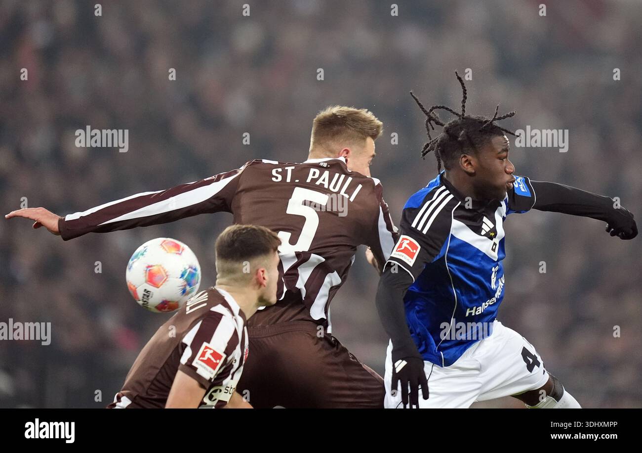 St. Pauli's Hauke Wahl, center, and Hamburger's Fabio Baldé in action ...