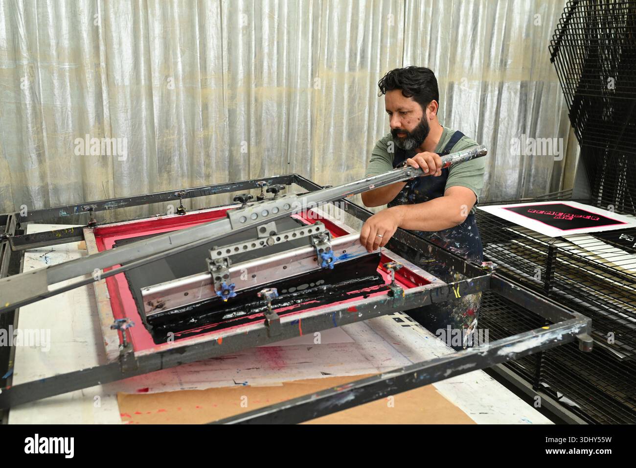Artist and printer Trent Walter at work using the printing press in his ...