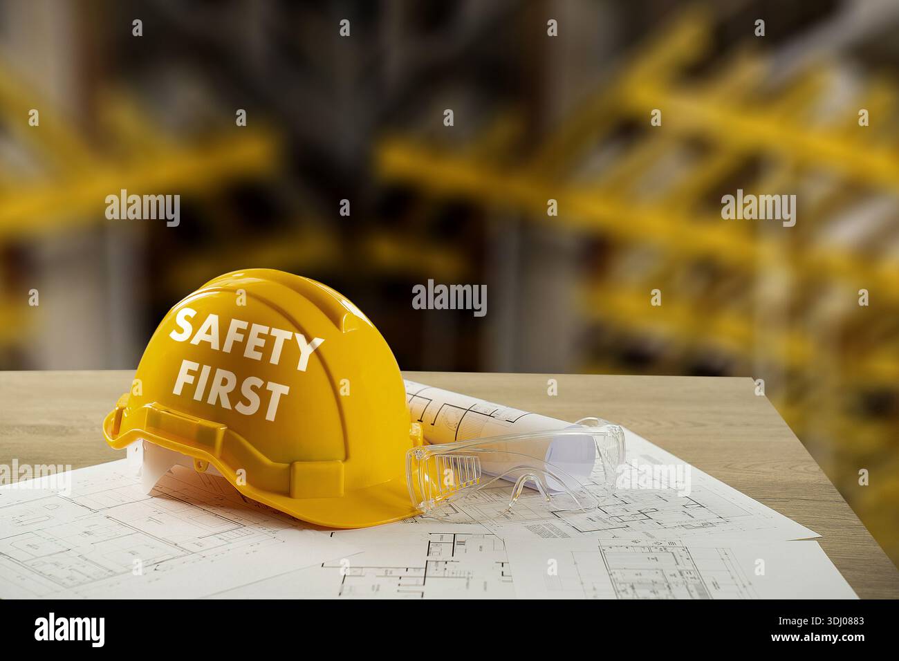 Safety First Construction manager shows a yellow hard hat on blueprints ...