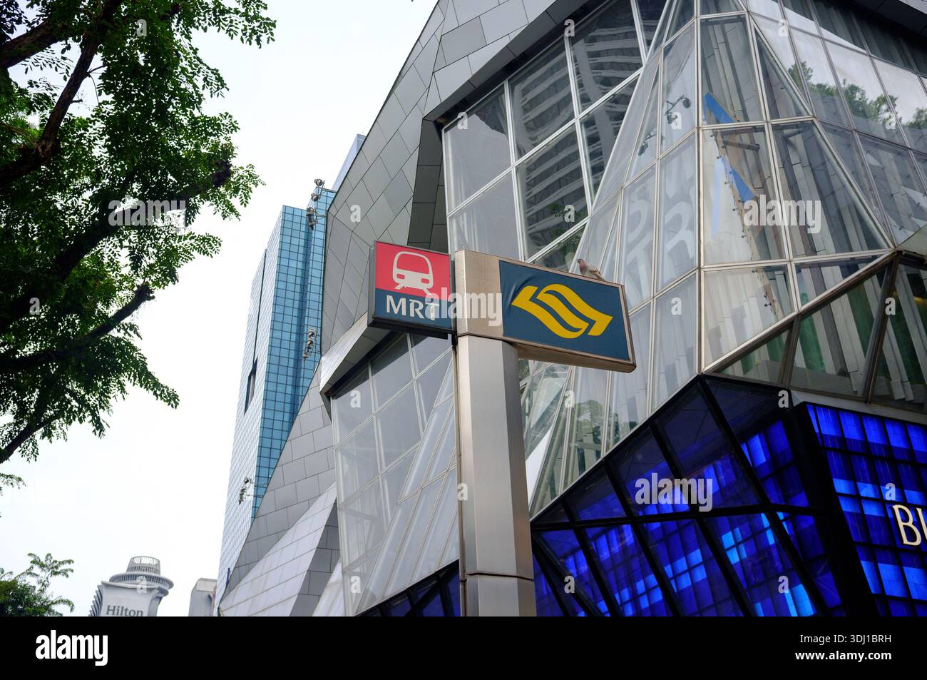 MRT station sign at Orchard Road Singapore against backdrop of a modern ...