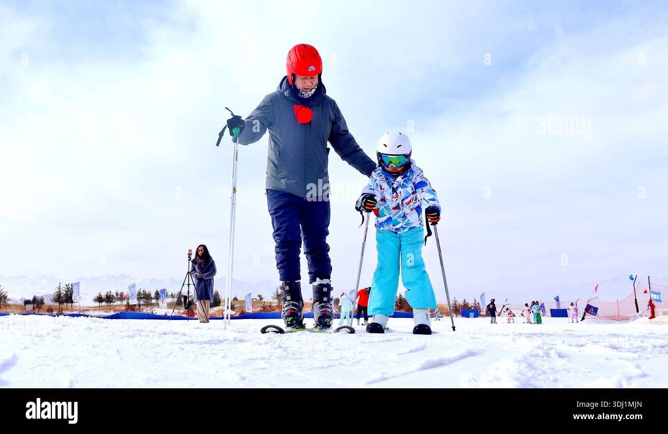 ZHANGYE, CHINA - JANUARY 24, 2026 - Parents guide their children in ...
