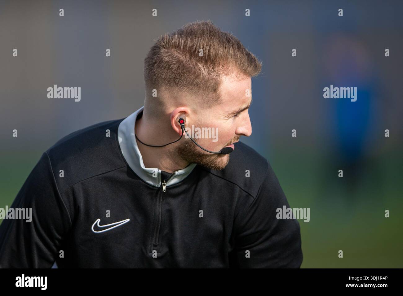 The match referee tests his headset before the Premier League PDL match ...