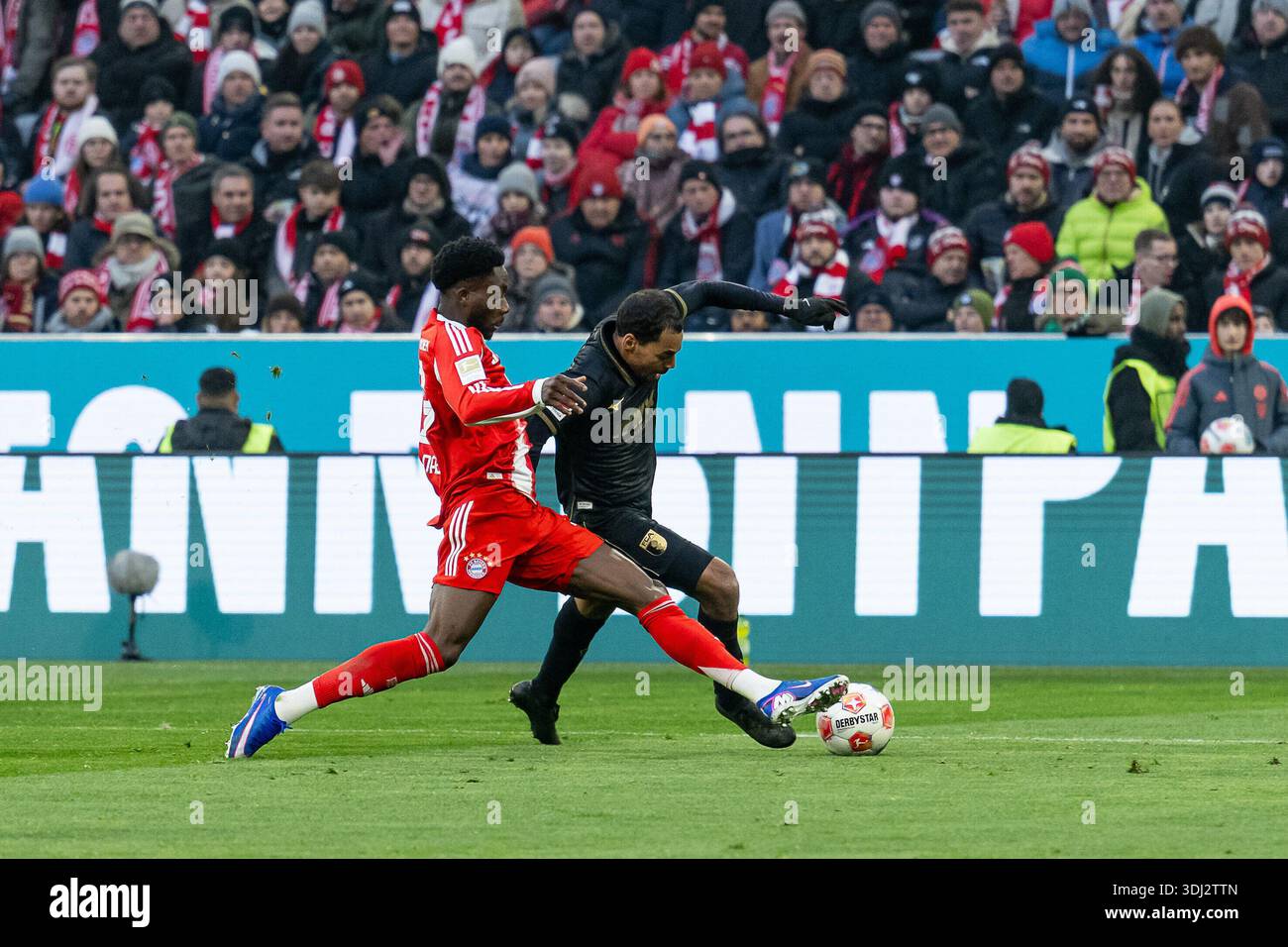 Fight for the ball / Duel between oAlphonso Davies (FC FC Bayern Munich ...