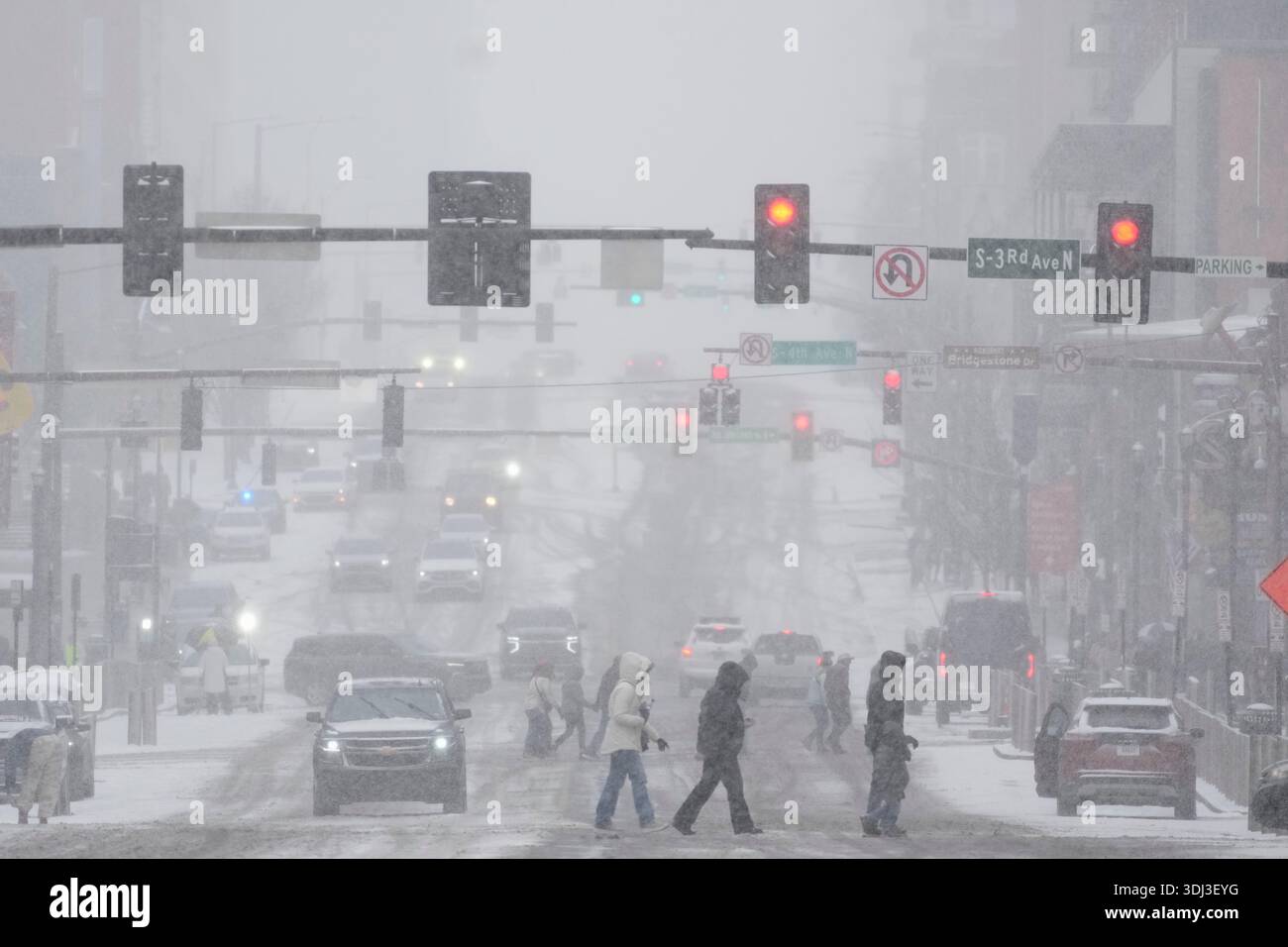 Pedestrians cross the street along Broadway during a winter storm ...