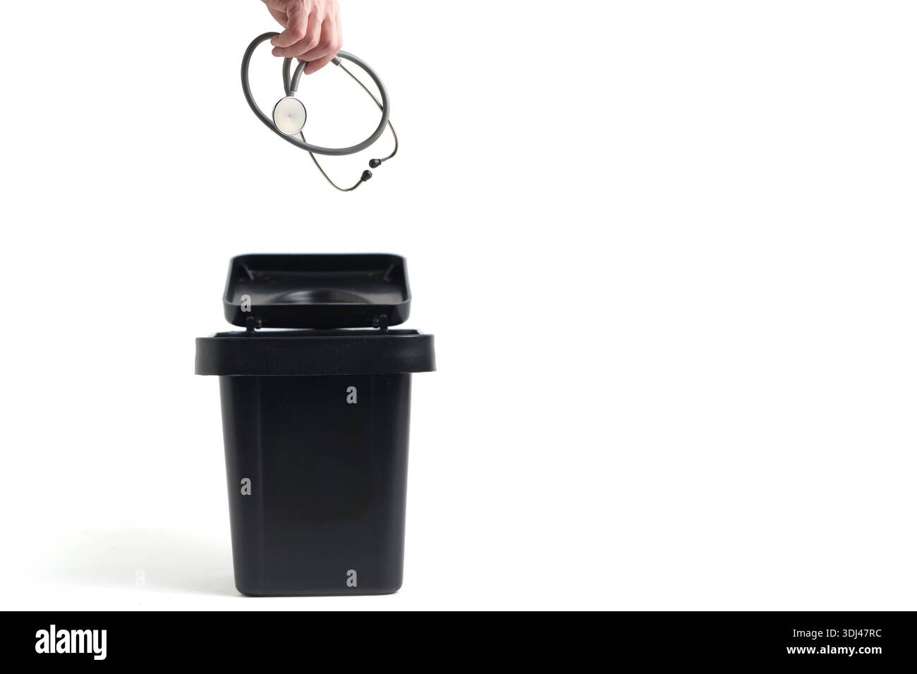 Hand throwing medical stethoscope into trash, representing career ...