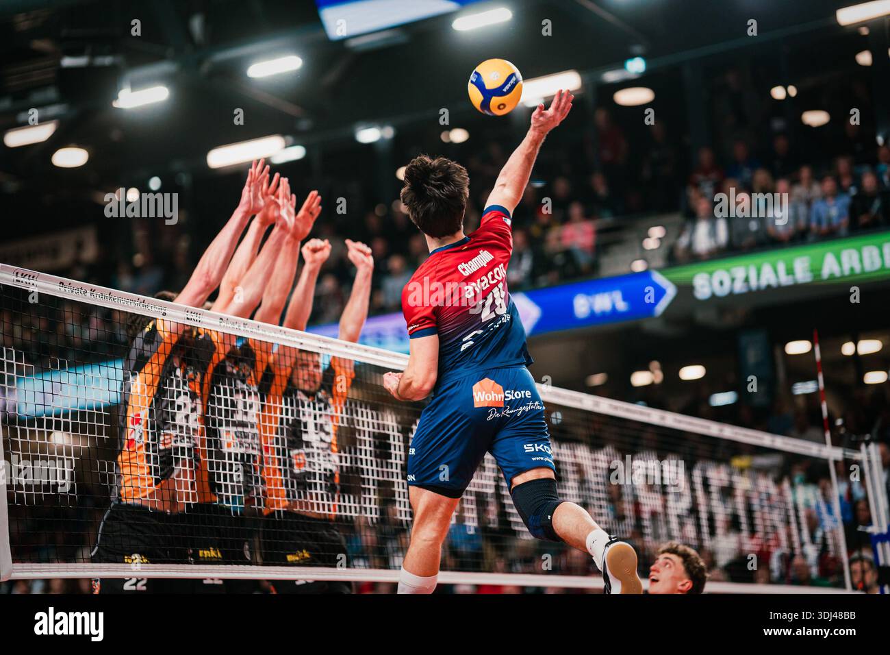 Ethan Champlin (SVG Lüneburg, 20) hits, behind a triple block from the ...