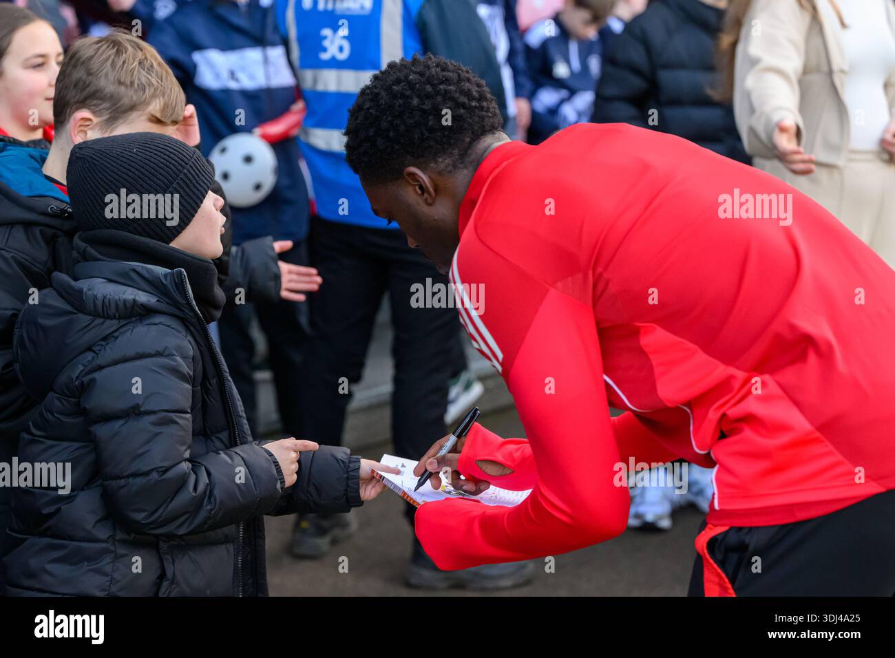 Daniel Udoh of Salford City FC signs an autograph for a young fan ...