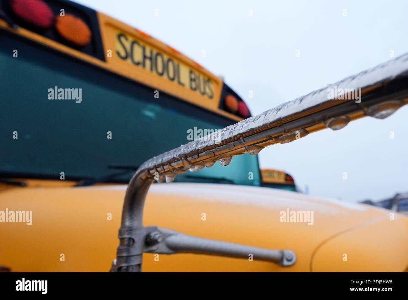 Icicles start to form on a school bus sits in a parking lot in ...