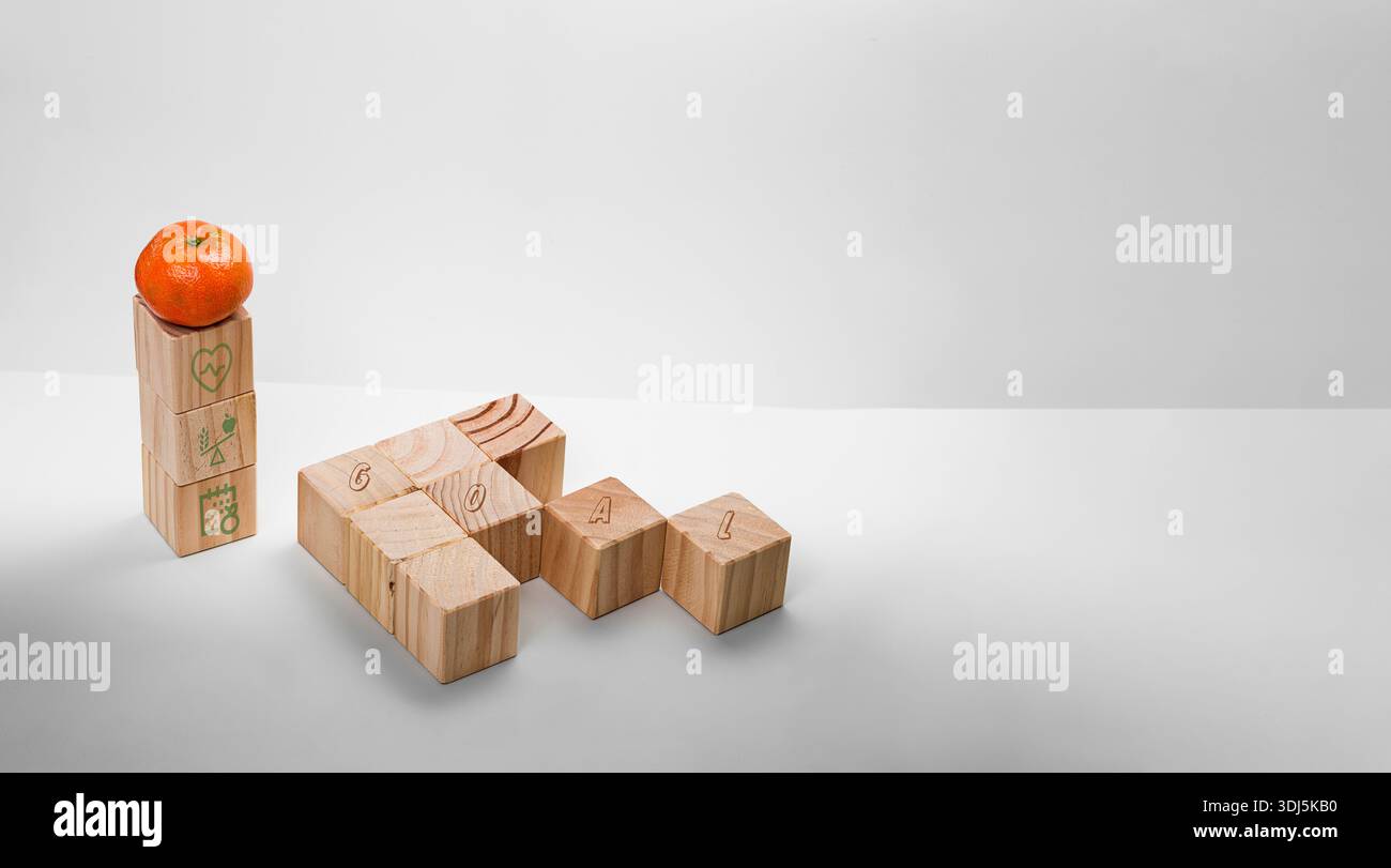 Minimal still life featuring wooden blocks spelling the word goal, with ...