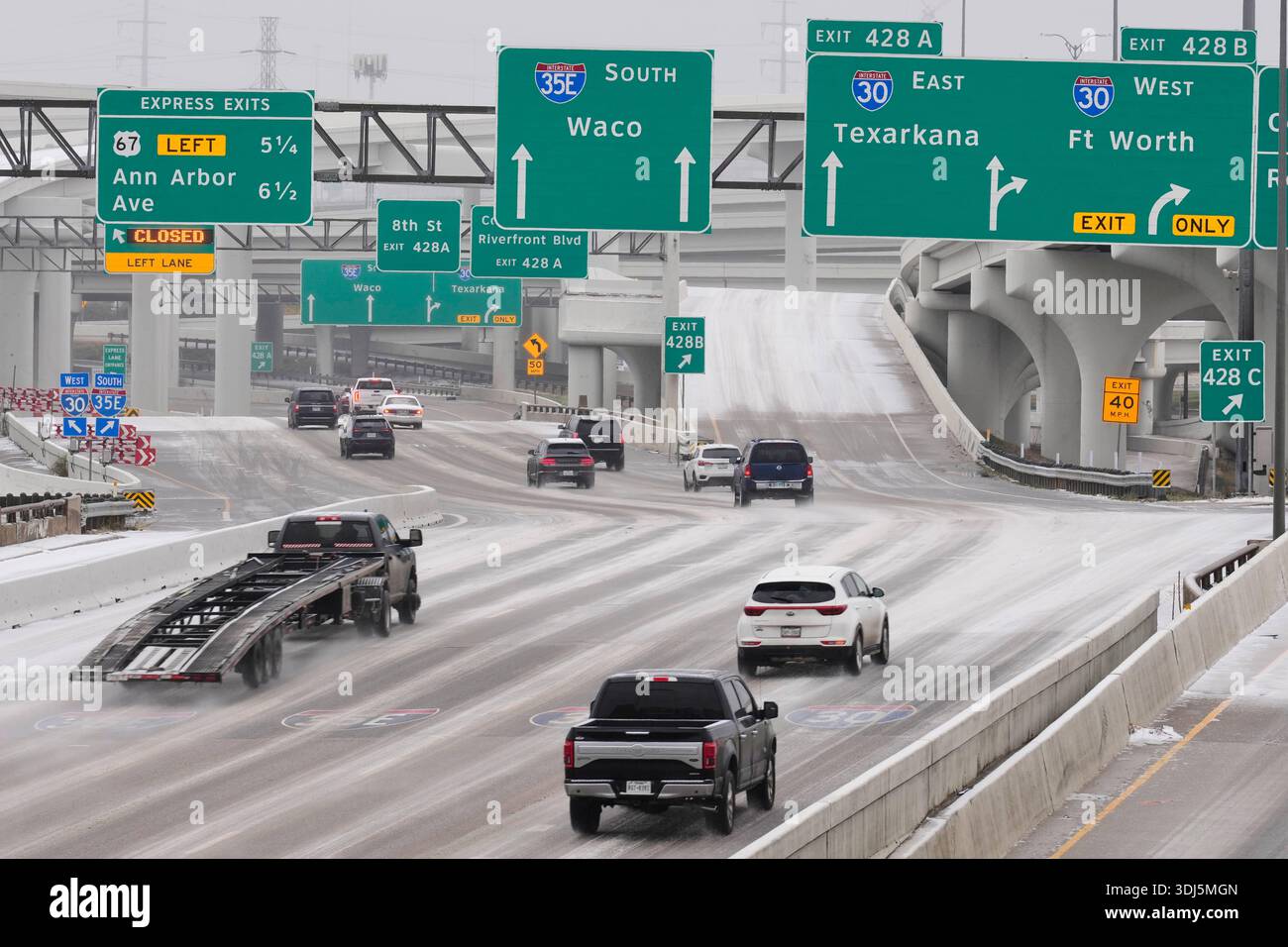 Drivers navigate icy and wet road conditions by the I35-I30 interchange ...