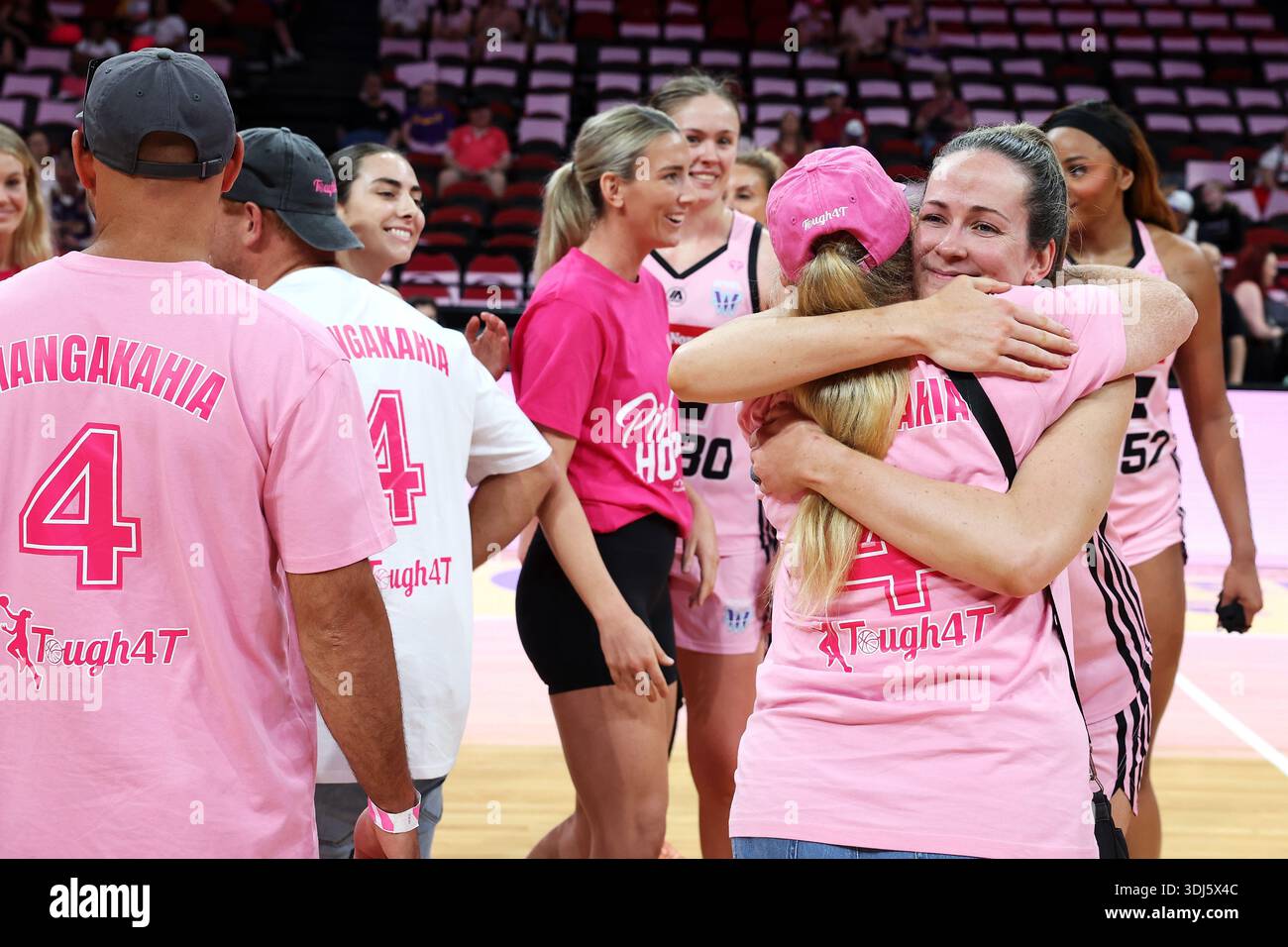 Keely Froling of the Flames and the Flames players embrace members of ...