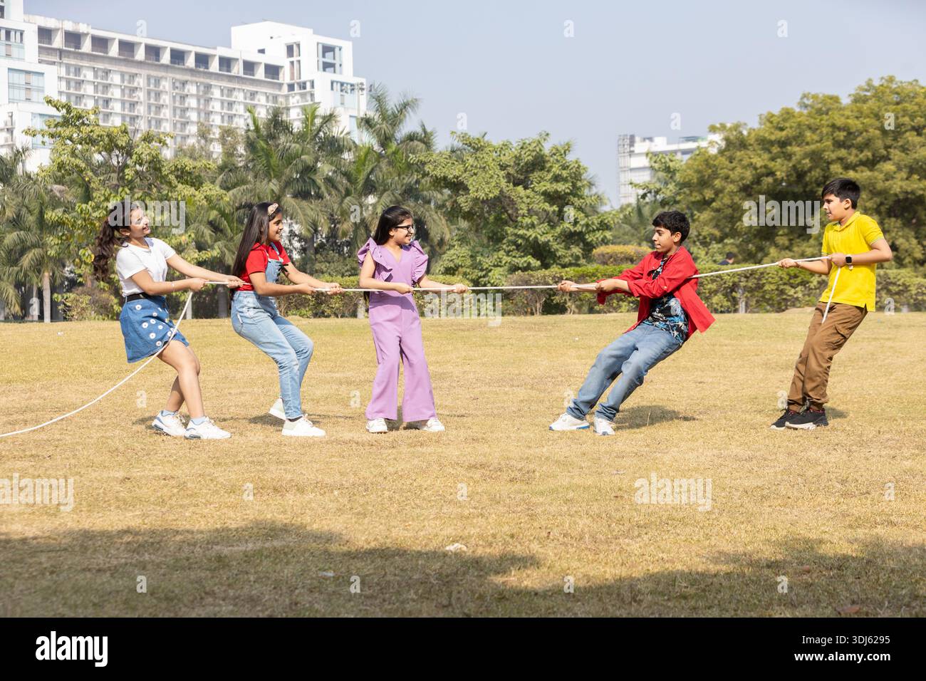 Group of playful indian kids enjoy pulling a rope during a fun outdoor ...