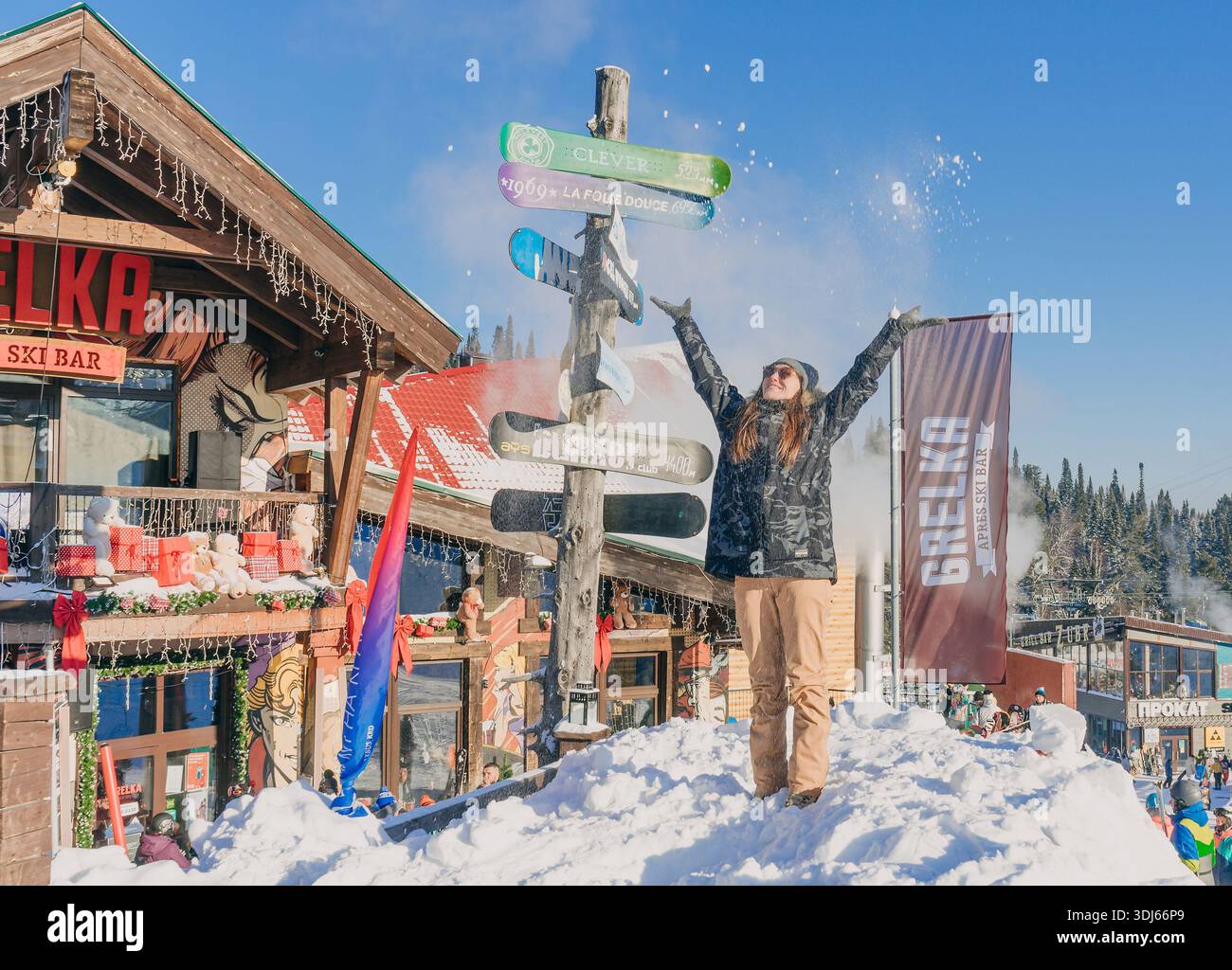 A young woman enthusiastically throws snow above her head. Sheregesh ...