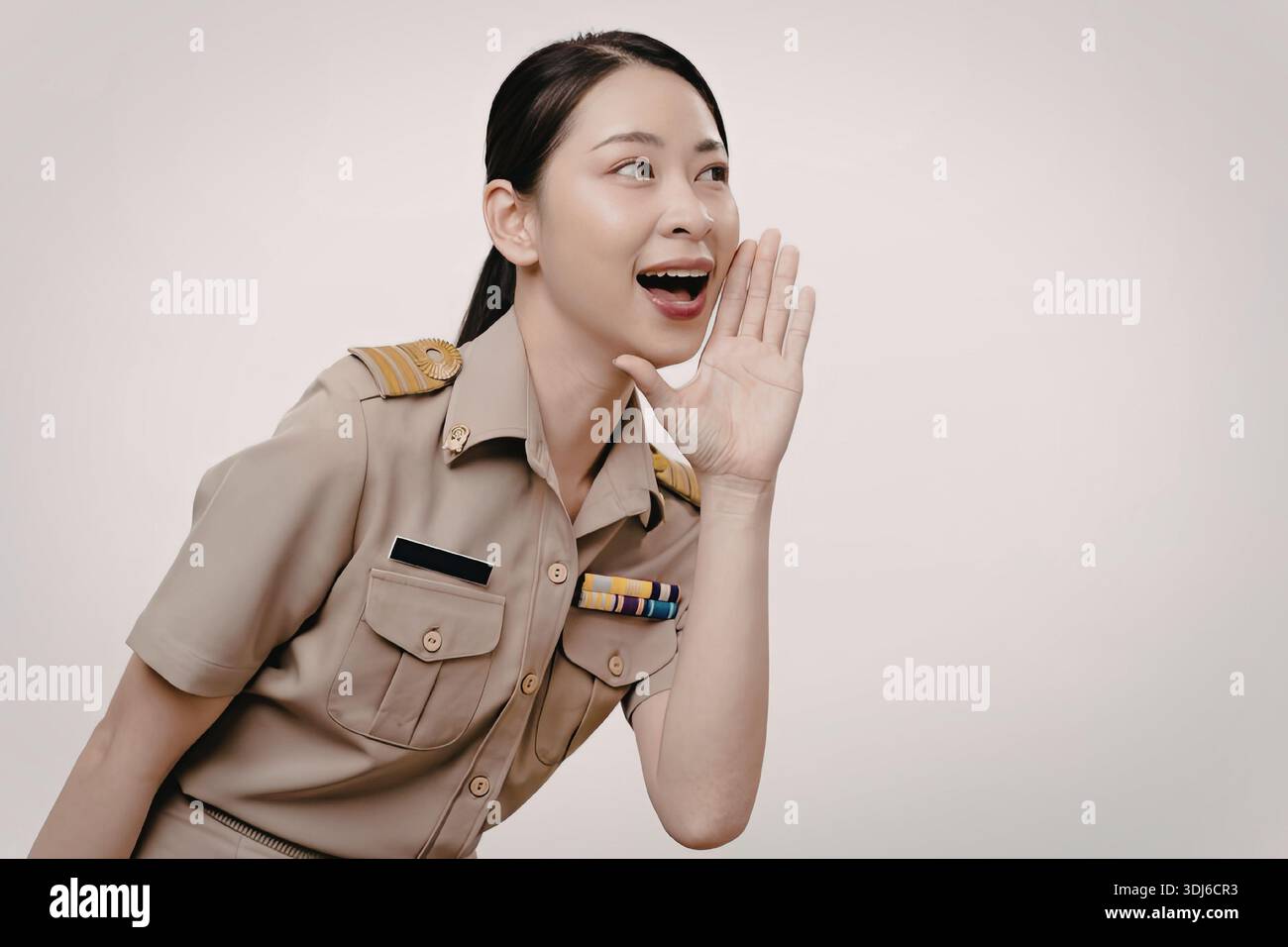 A young woman in a military uniform is saluting with her right hand ...