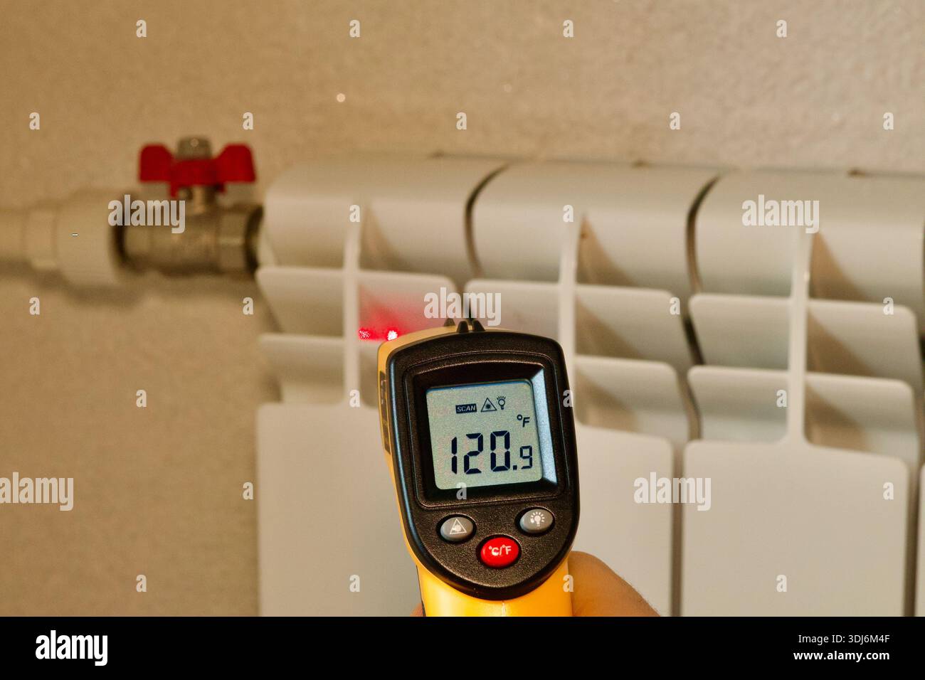 Infrared thermometer measuring hot radiator temperature, concept of ...