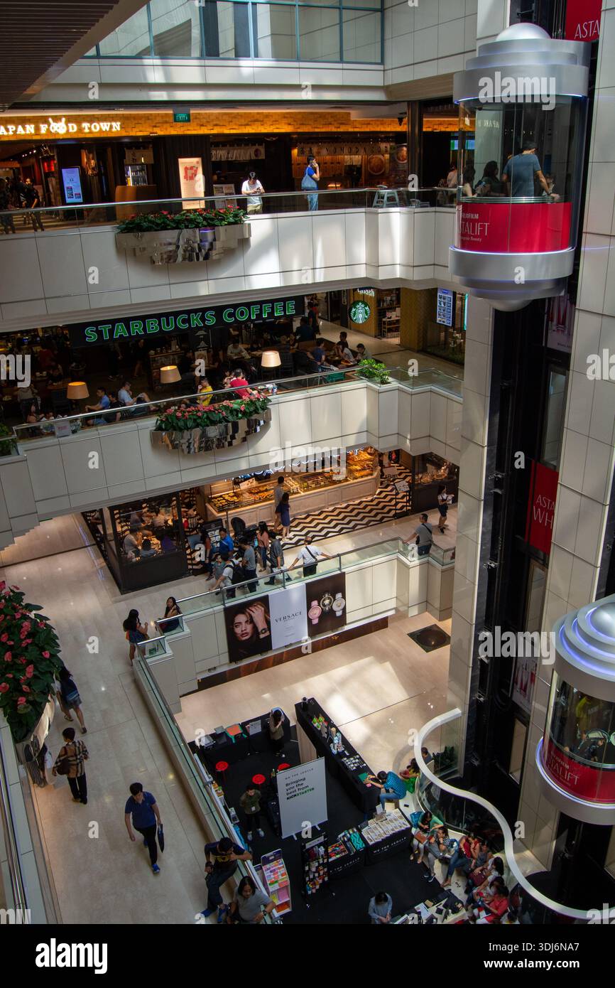 A modern shopping mall interior with multiple levels, featuring shops ...