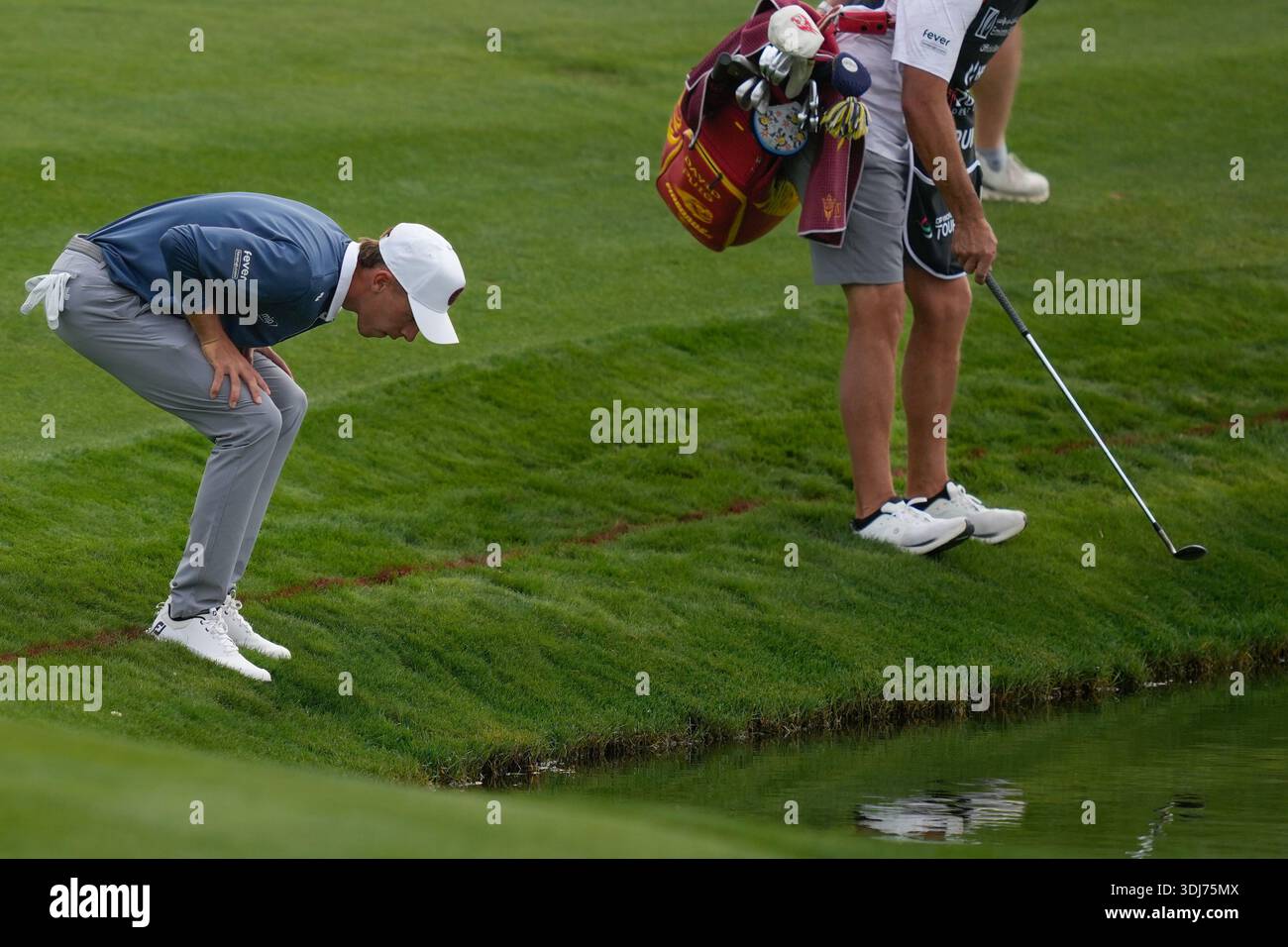 David Puig of Spain and his caddie look for the ball on 4th hole during ...