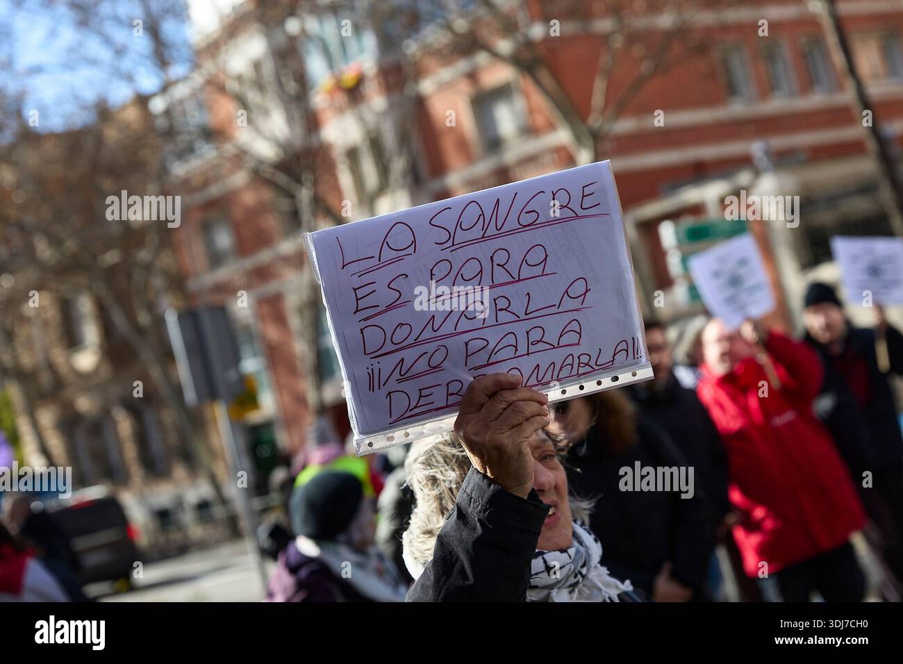 Demonstrator carries a banner with the slogan 'Blood is for giving, not ...