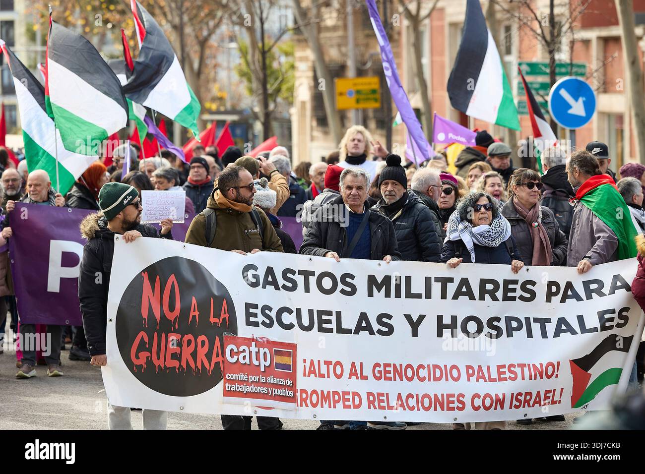 Demonstrators carry a banner with the slogan 'Military spending for ...