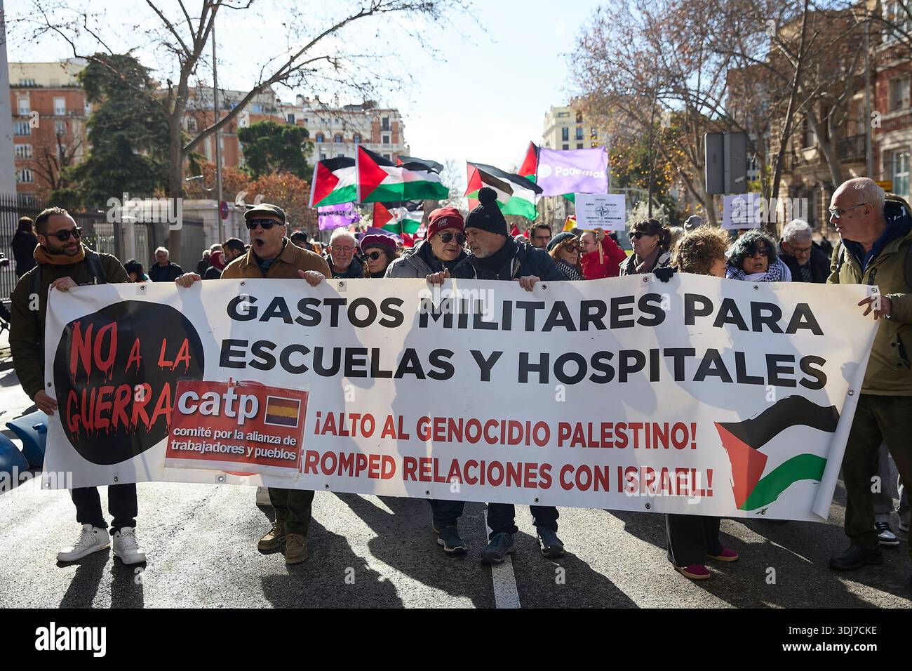 Demonstrator carries a banner with the slogan 'Military spending for ...