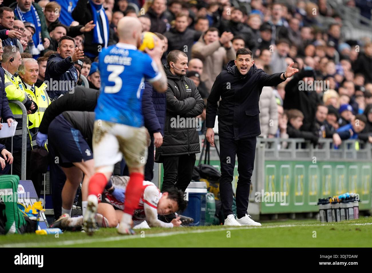 Portsmouth manager John Mousinho (right) gestures on the touchline ...