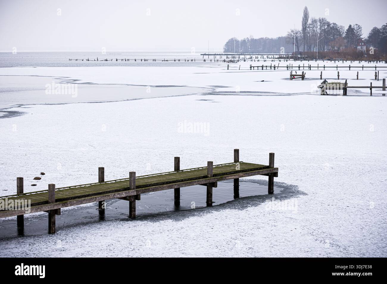 Steinhude, Germany. 25th Jan, 2026. A jetty juts out into the partially ...
