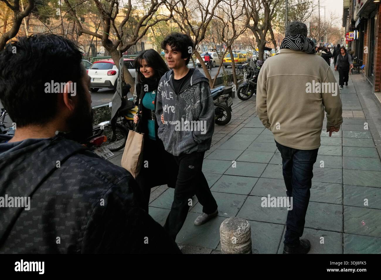People walk on a sidewalk at the Enqelab-e-Eslami (Islamic Revolution ...