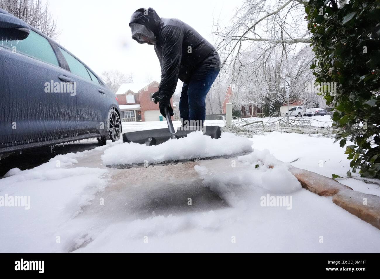 David Bentley shovels ice and snow from his driveway during a winter ...