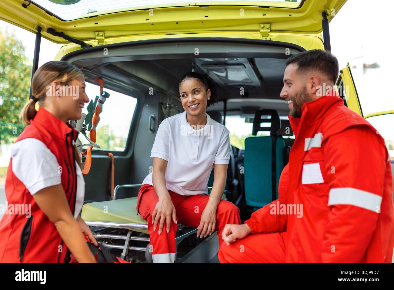 Paramedics and doctor standing on the side ambulance. Doctor is ...
