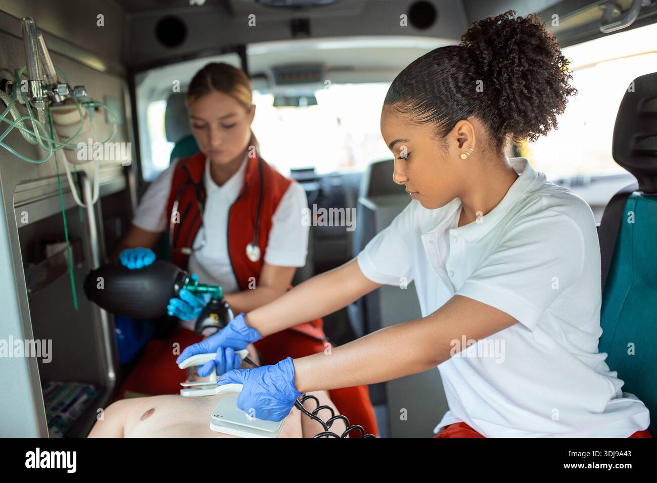 Paramedic using defibrillator (AED) in conducting a basic ...