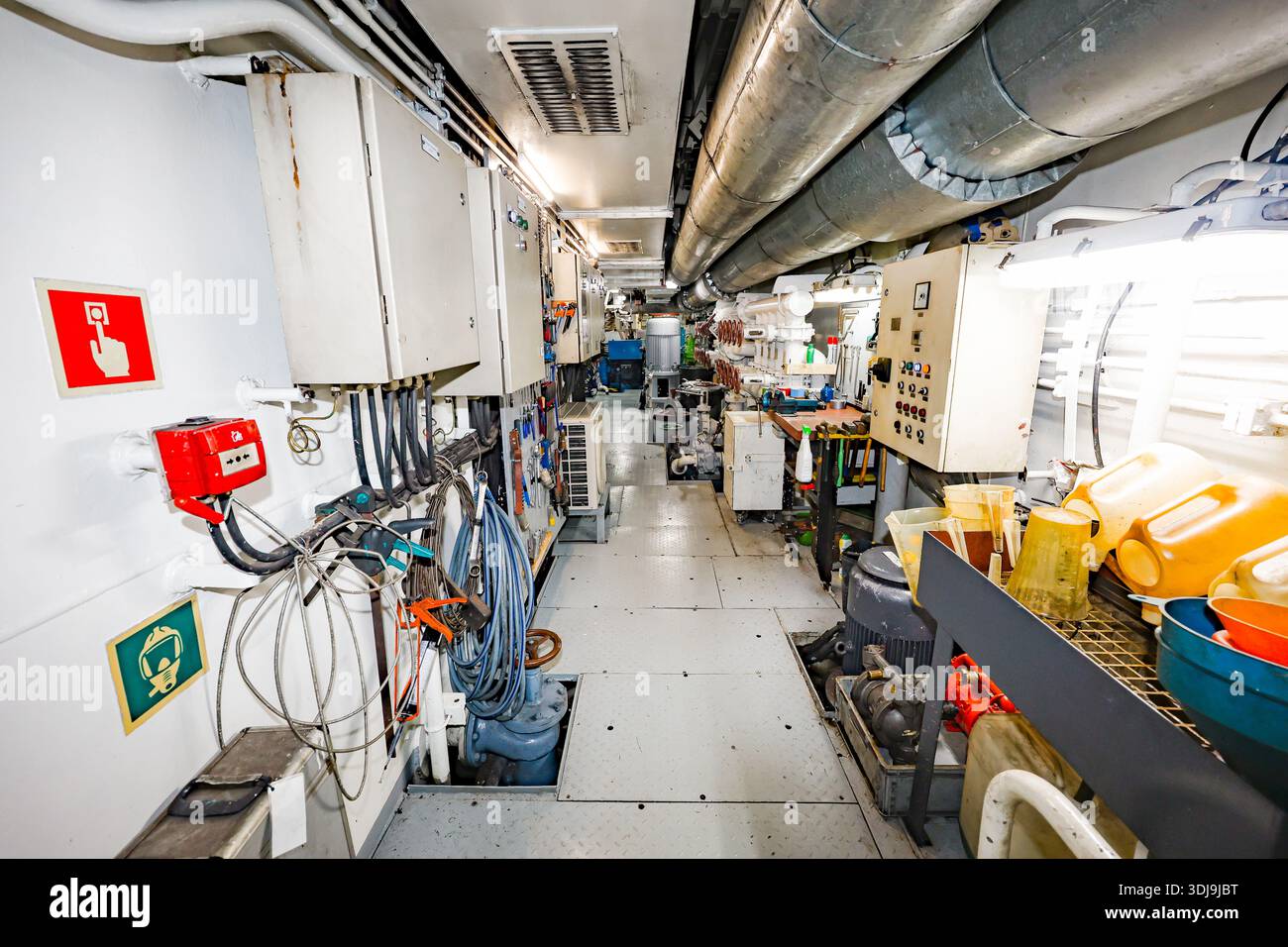 Ship engine room corridor with control panels, tools, pipes and ...