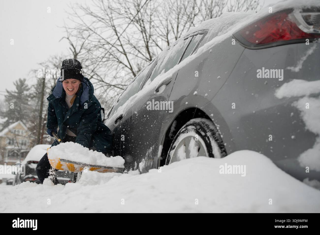 Anna Knappenberger digs snow from around her car during a winter storm ...