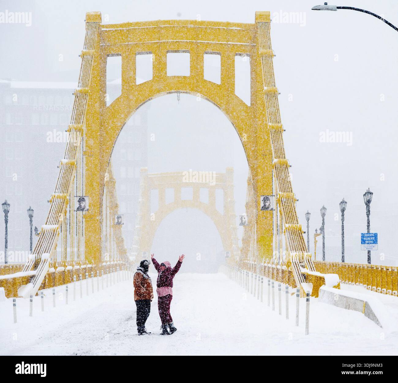 A couple walks and makes the best of the snow storm in the middle of ...