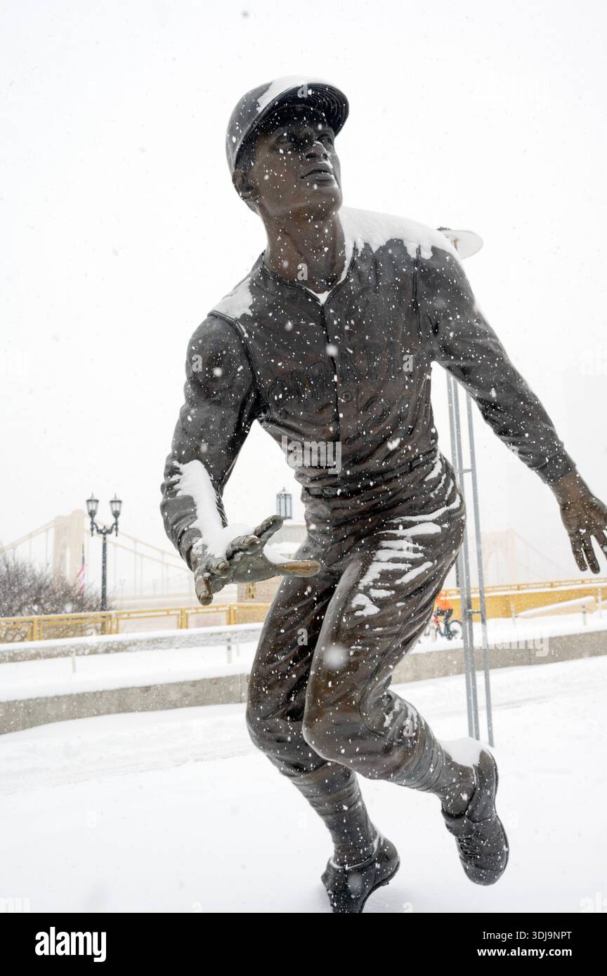 Snow falls on the statue of Roberto Clement outside of PNC Park during ...