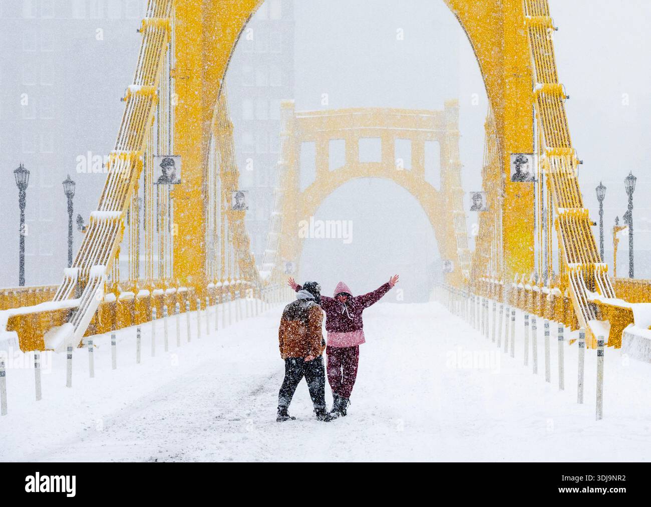 A couple walks and makes the best of the snow storm in the middle of ...