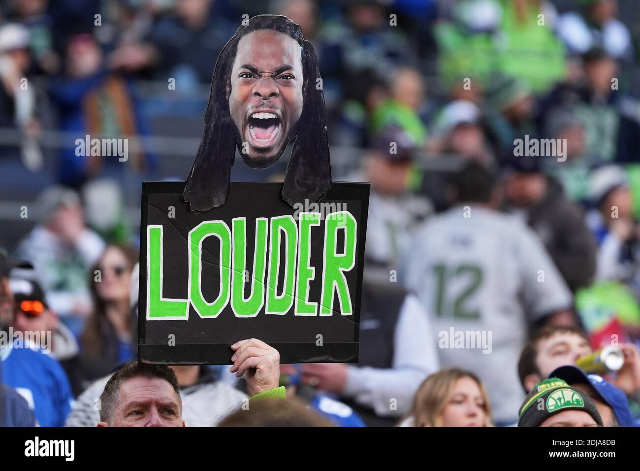 A fan holds up an image of former NFL player Richard Sherman before the ...