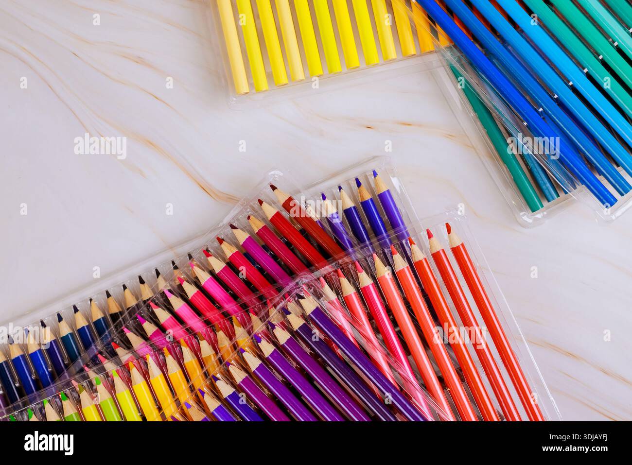 Colored pencils in packs display various hues, lined up on light ...