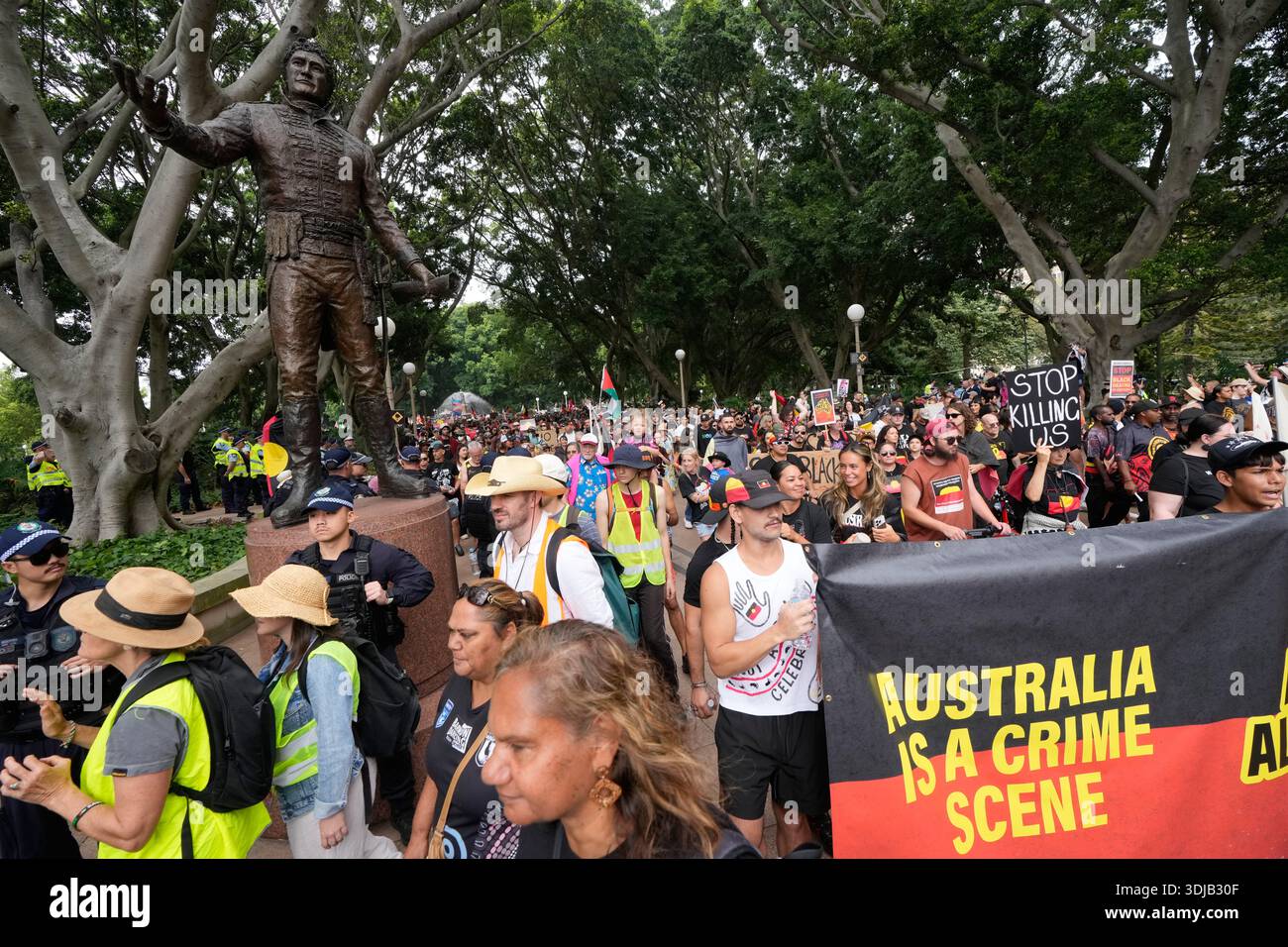 "Demonstrators walk past a statue of Lachlan Macquarie, a British army ...