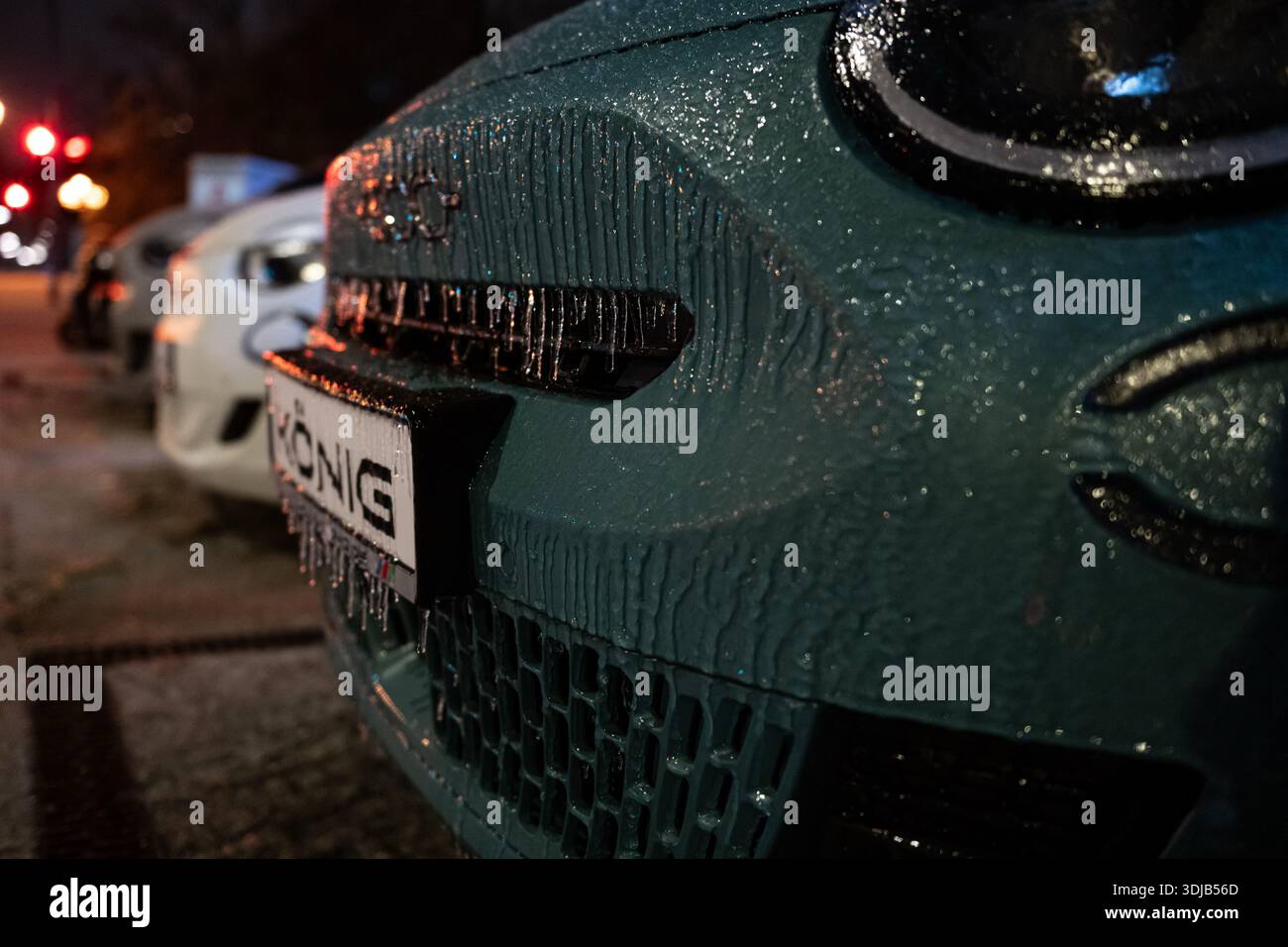 26 January 2026, Berlin: A thin layer of ice lies over a car in the ...