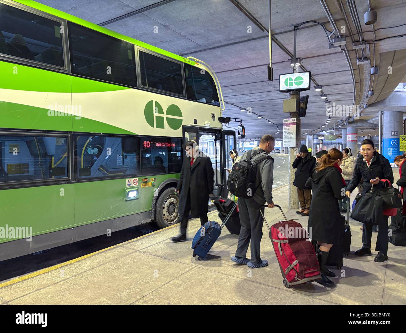 GO Transit bus boarding with passengers and luggage at a Toronto area ...