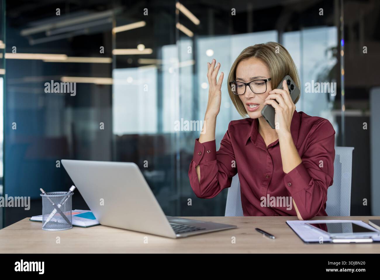 Frustrated businesswoman talking on a smartphone with an angry ...