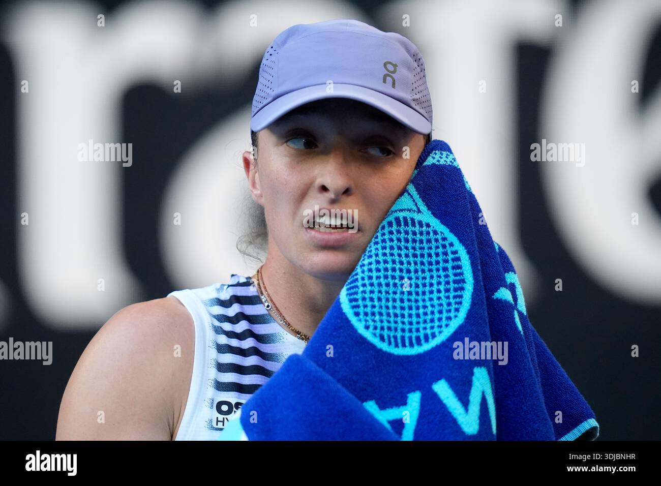 Iga Swiatek of Poland wipes sweat from her face during her fourth round ...
