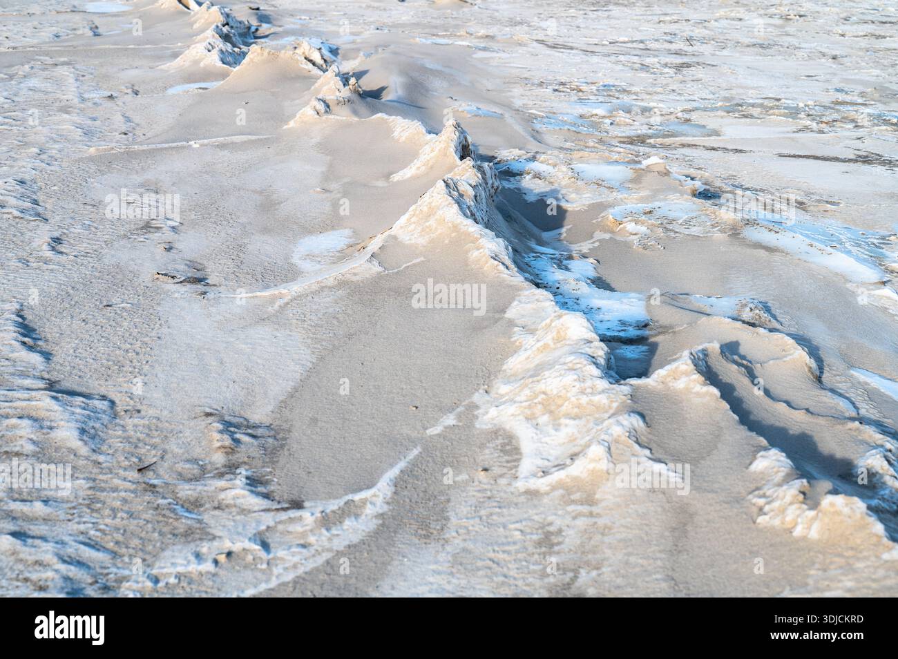 Frozen sand dunes with blue ice formations on Baltic Sea beach in ...