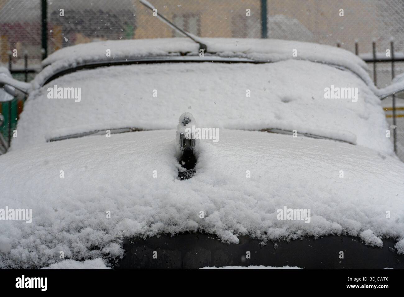 Car partially covered with fresh snow after winter snowfall. Cold ...