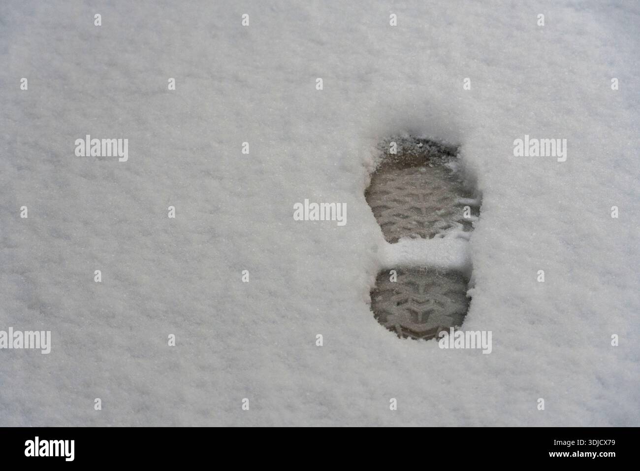 Clear shoe prints trail through untouched snow, capturing a moment of ...