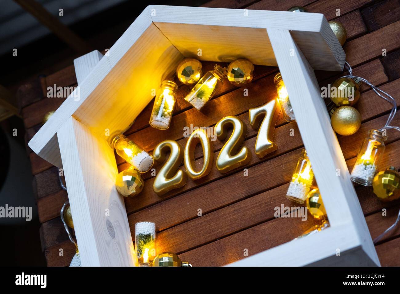 Golden figures number 2027 and tiny home on background of cozy windows ...